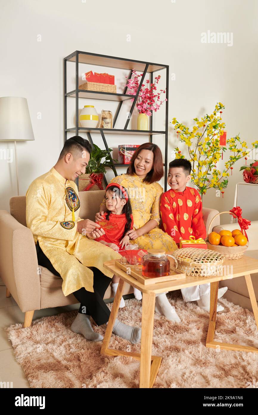 Father giving lucky money envelope to little daughter as Spring ...
