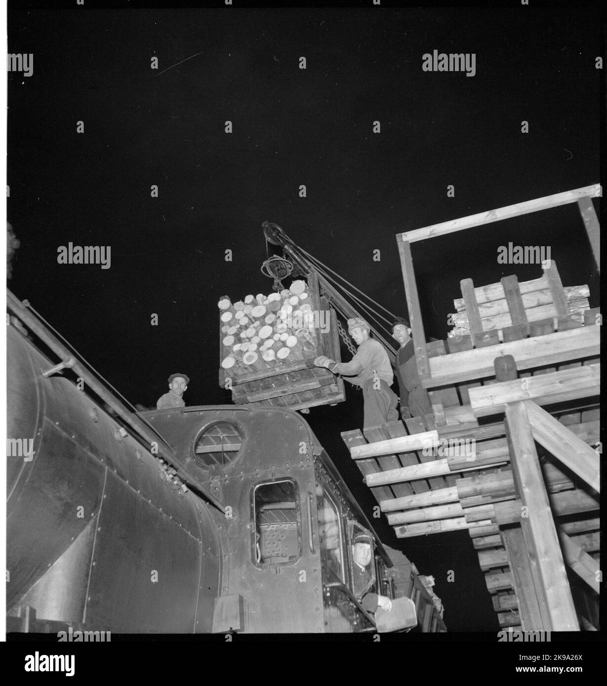 Loading wood on a steam locomotive Stock Photo - Alamy