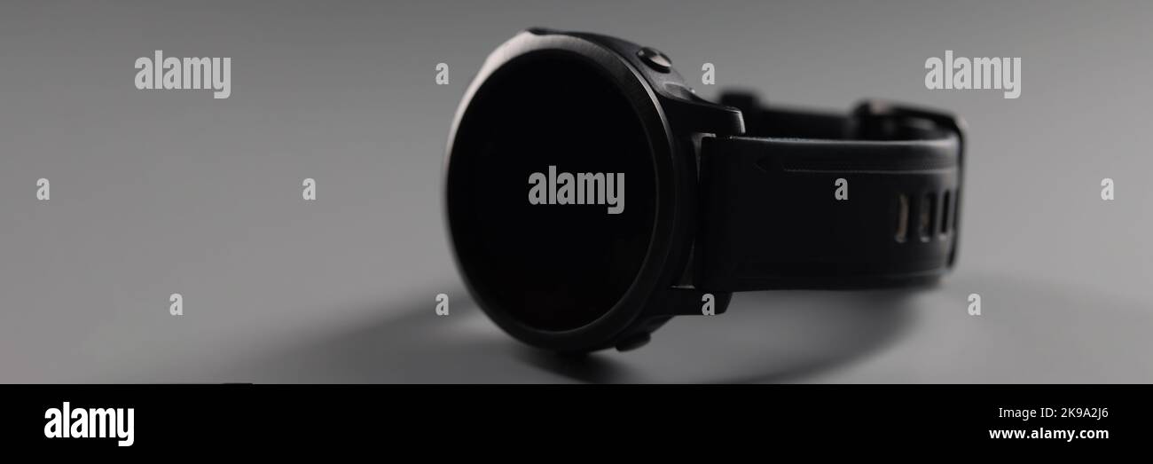 Trendy minimalistic device, black male wristwatch lying on grey ...