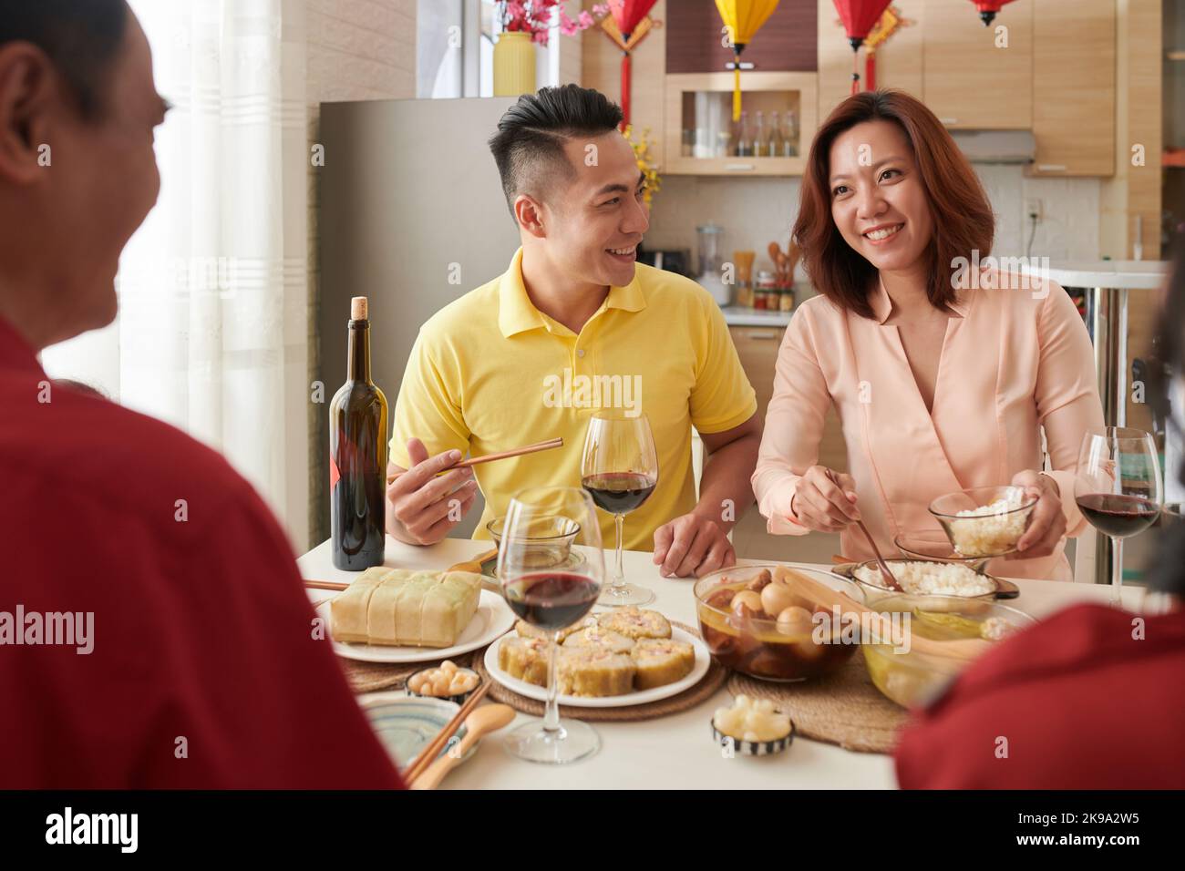Smiling Asian couple enjoying family dinner and eating traditional ...
