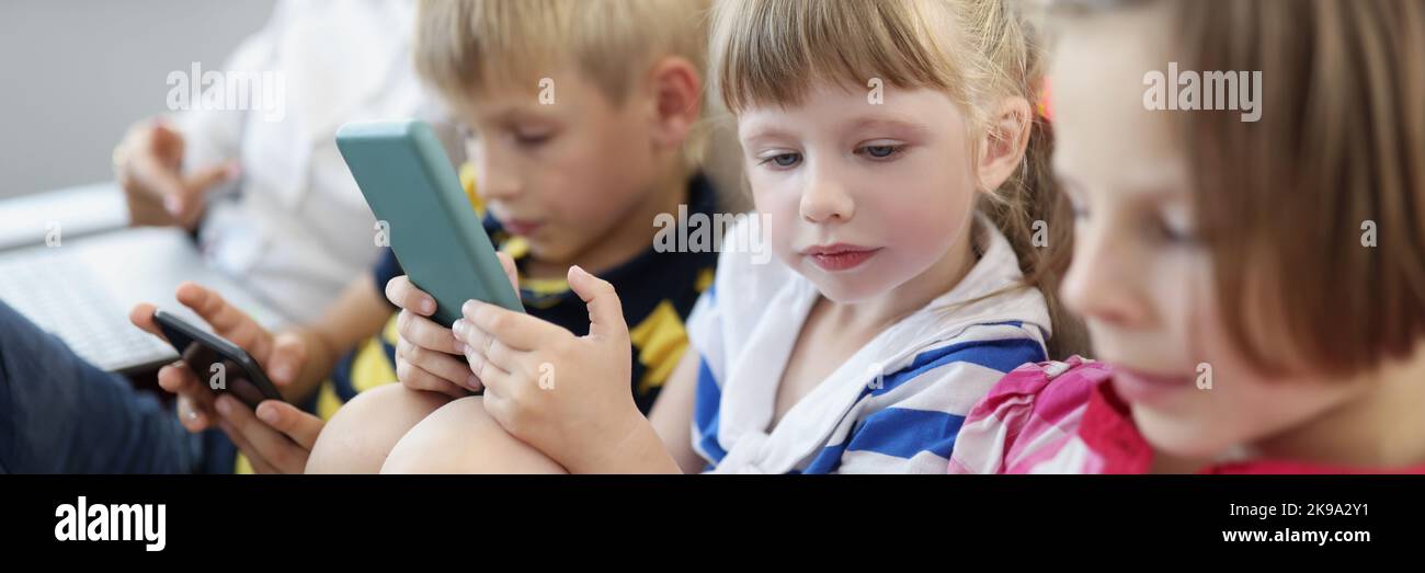 Children at home, stare at smartphone screens, addiction to modern ...