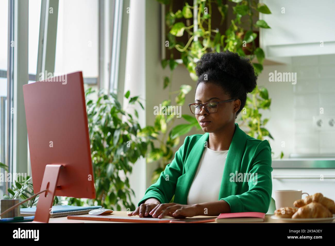 Successful African American woman working as editor magazine typing ...