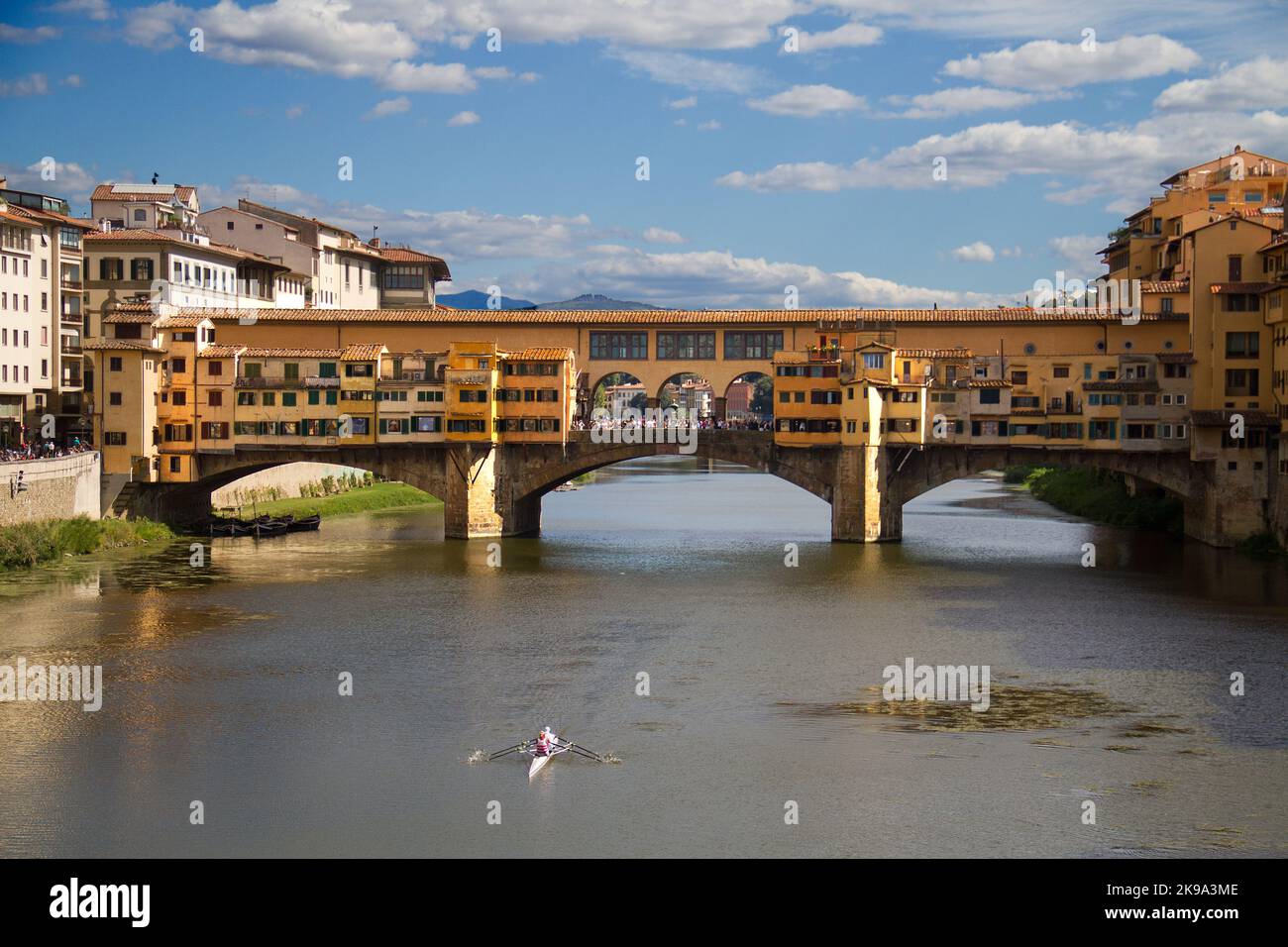 Arch bridge, the Ponte Vecchio in Florence, houses reflected in flowing ...