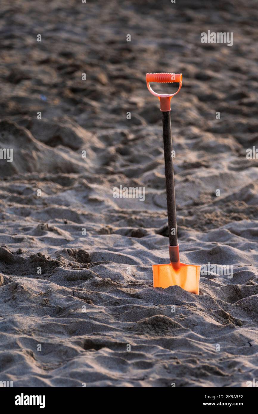 A toy plastic spade left in the sand on Fistral beach in Newquay in ...