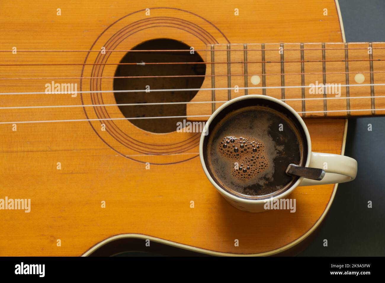 wooden guitar and a cup of coffee on a dark background Stock Photo - Alamy