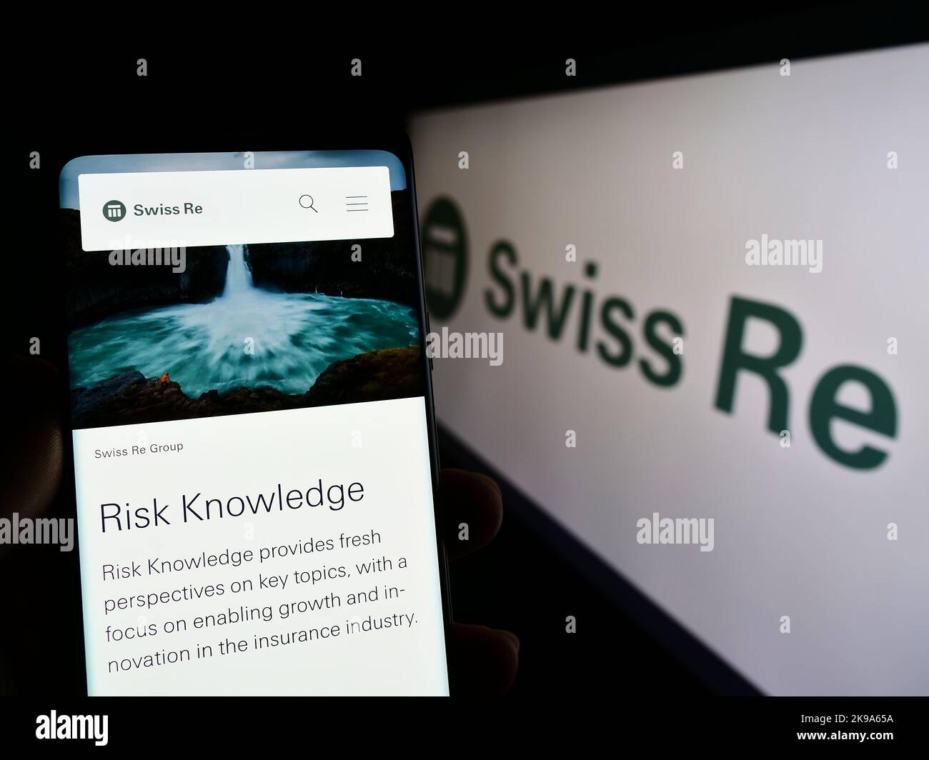 Person holding smartphone with website of reinsurance company Swiss Re ...