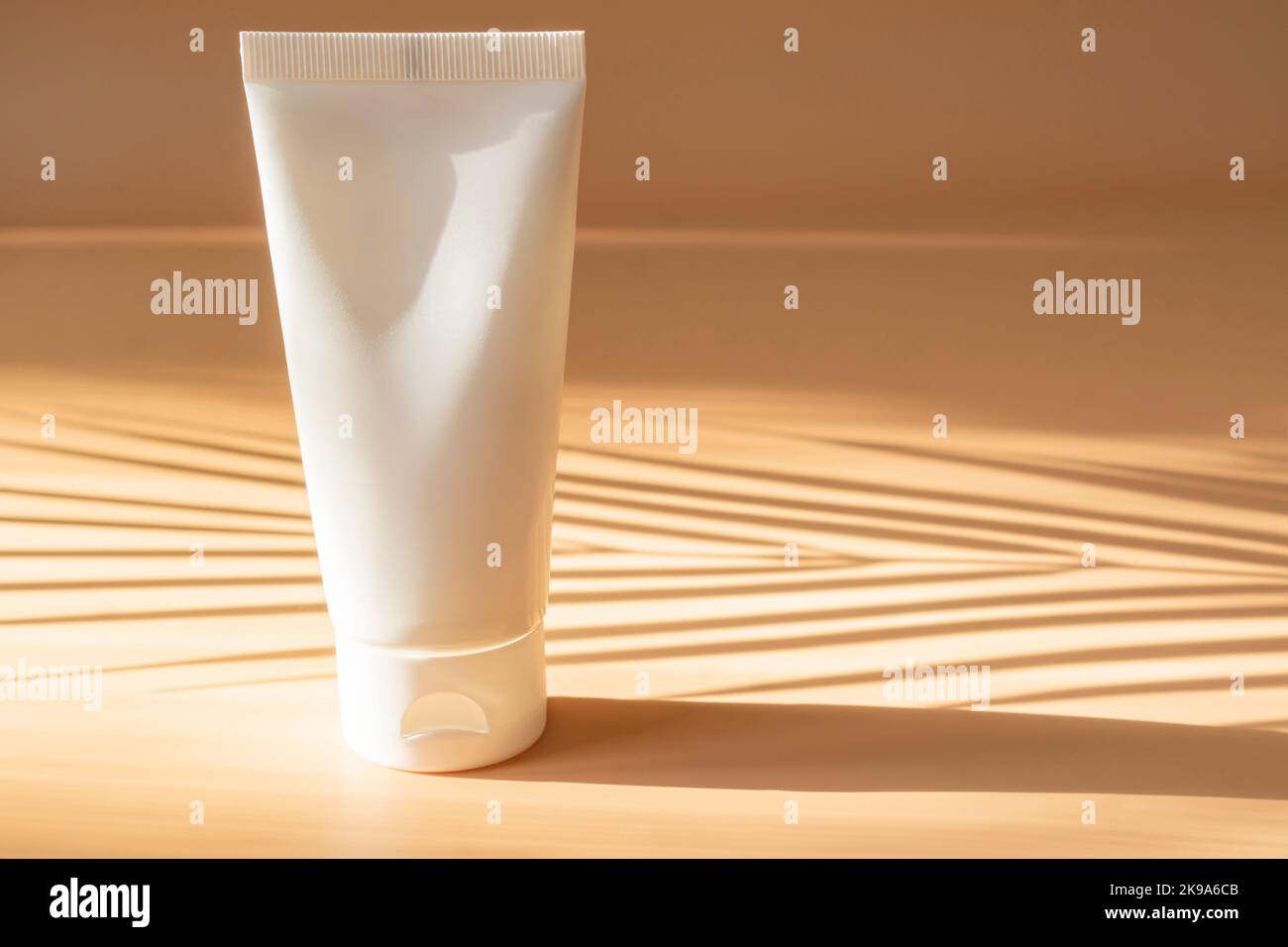 Blank plastic tube mockup for cosmetics with cap on beige background ...