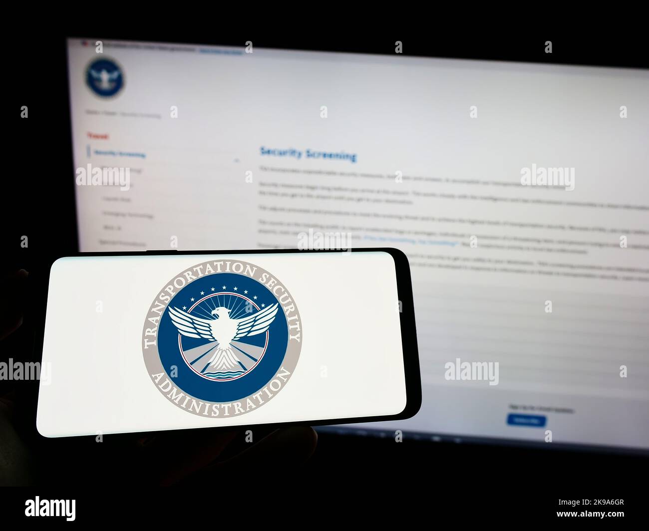 Person holding mobile phone with seal of Transportation Security ...