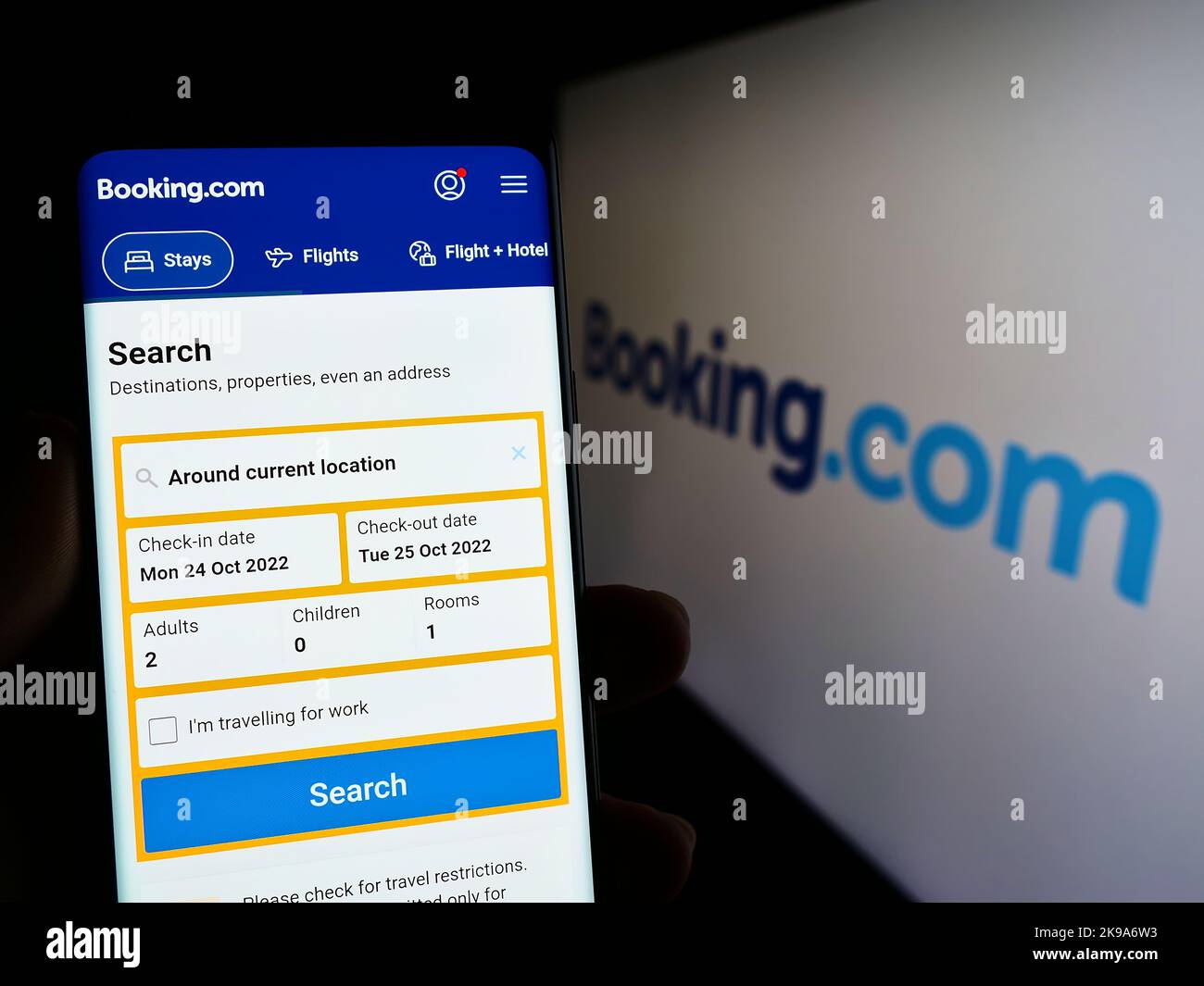 Person holding cellphone with web page of Dutch online travel agency ...