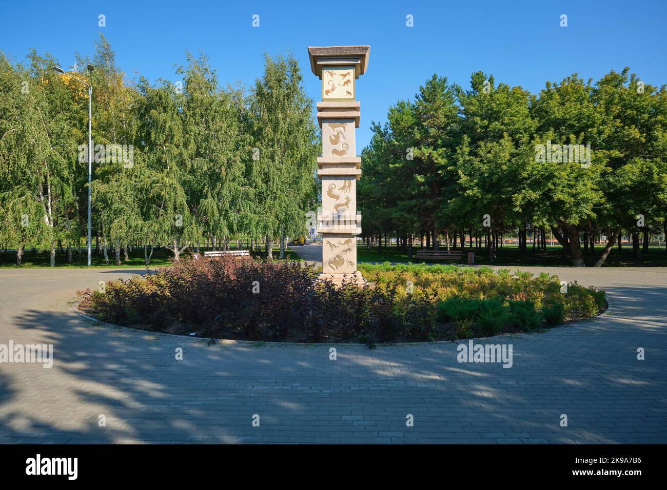 A large stone column, stele with ancient animal carvings around the ...