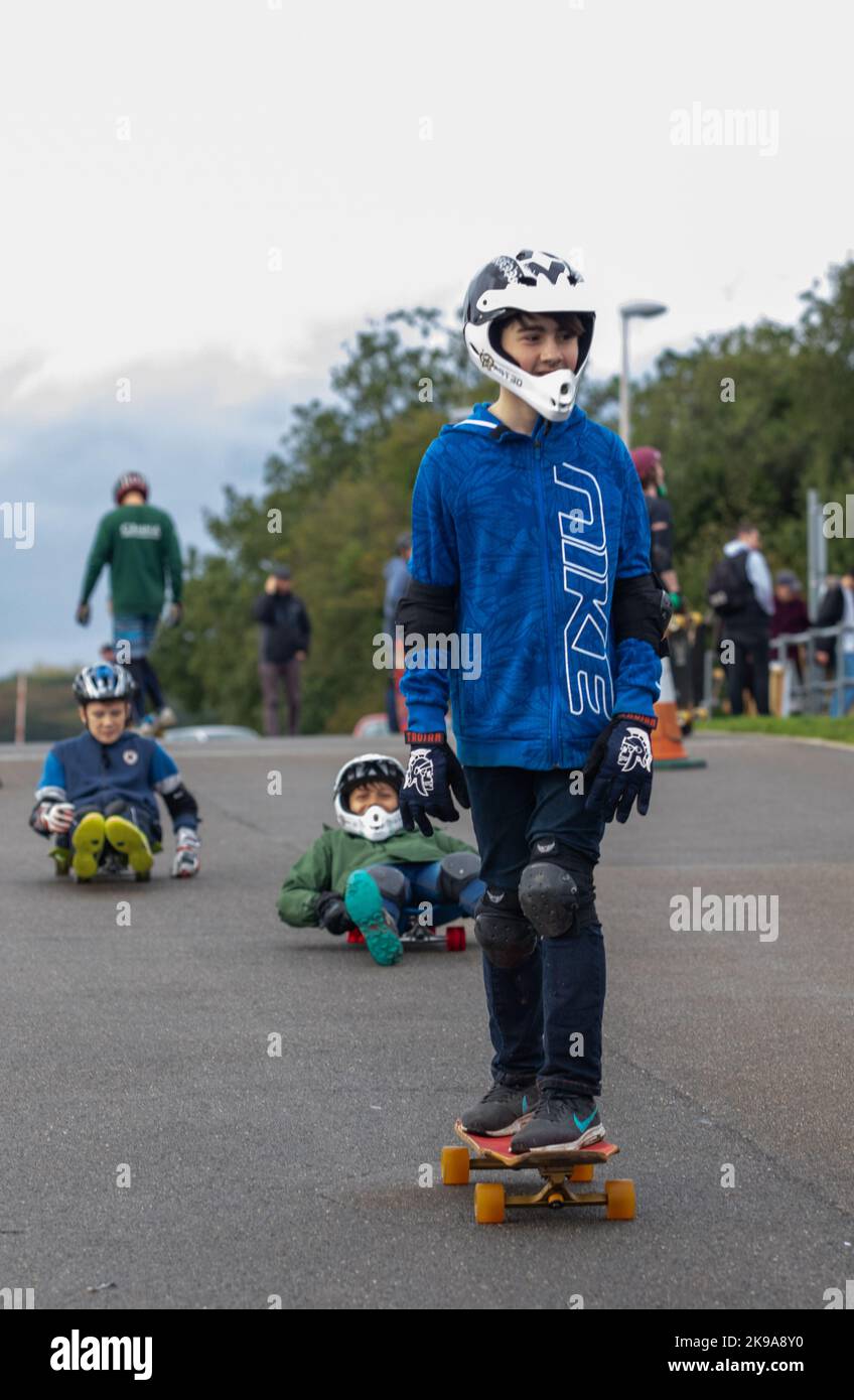 Standing young skateboarder and two buckboarders start a free ride at ...