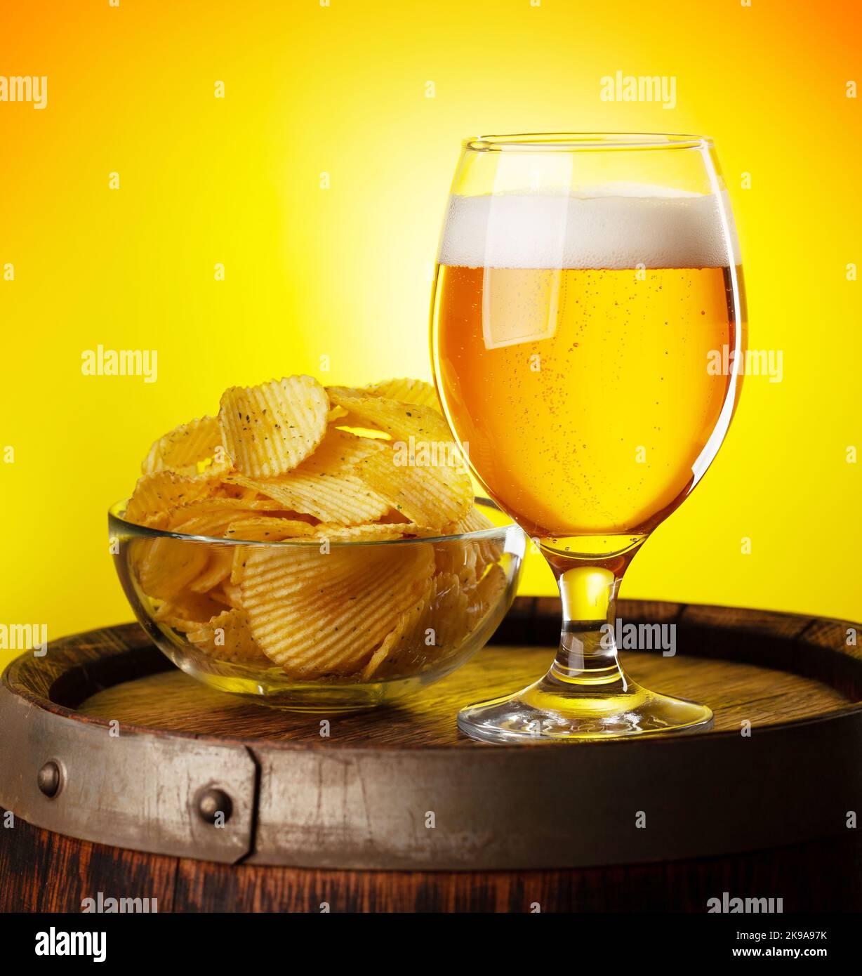 Beer glass and potato chips on wooden barrel. With copy space Stock ...