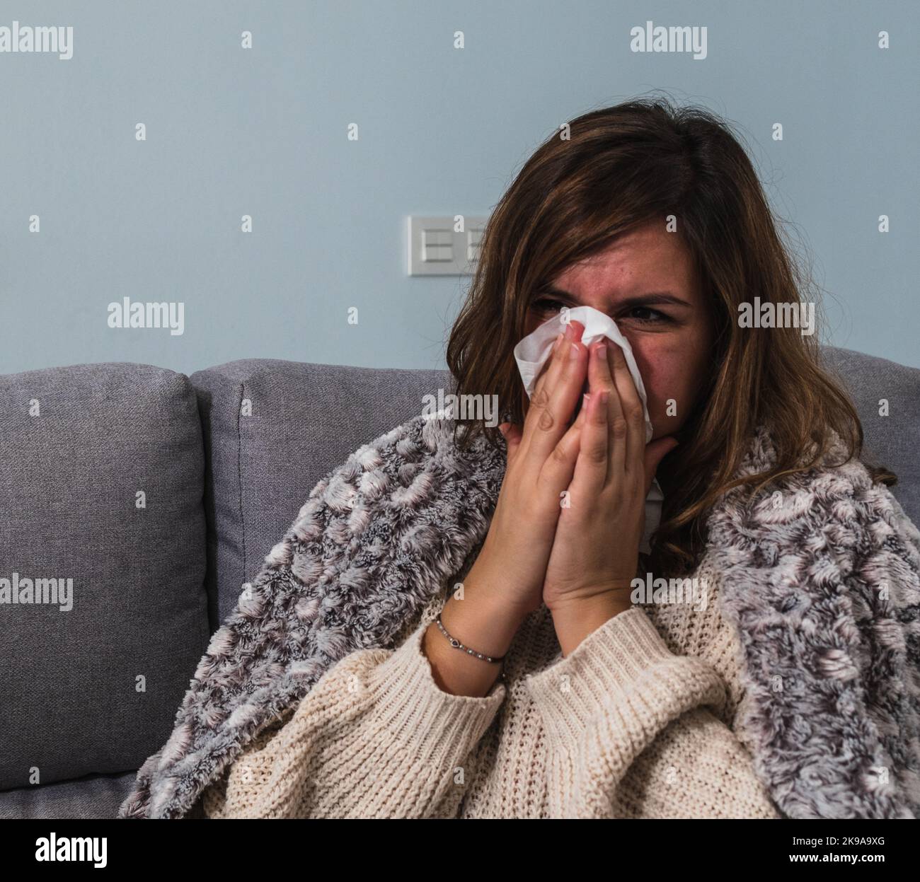 Woman feeling really sick blowing her nose with a tissue Stock Photo ...
