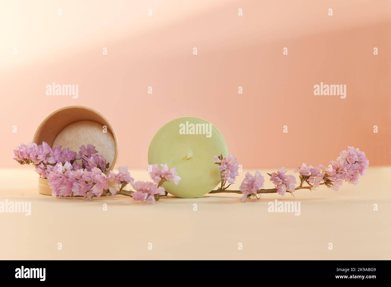 solid shampoo in sunlight with dried pink flowers. Eco friendly bar on ...