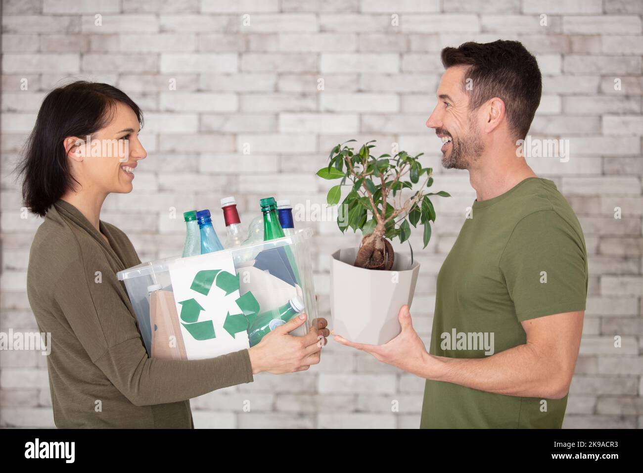 couple holding recycling and a plant looking at each other Stock Photo ...