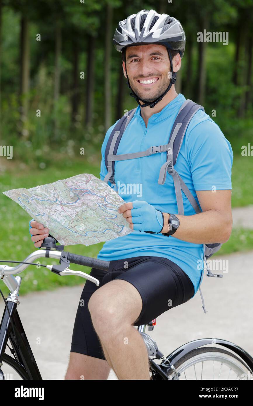happy man on bike checking map Stock Photo - Alamy