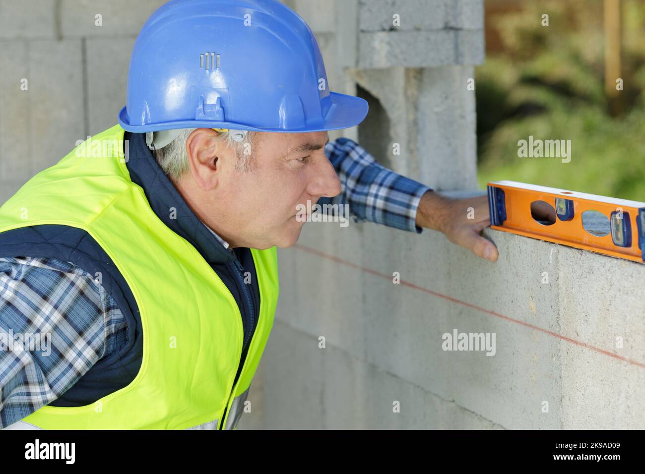 male worker fixing a wall at a construction site Stock Photo - Alamy