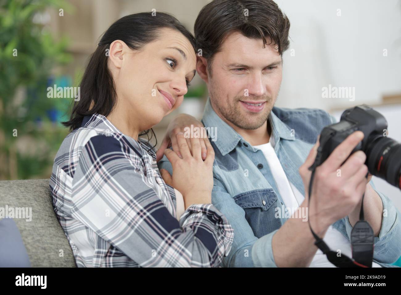 happy smiling couple watching photos from travel on digital camera ...