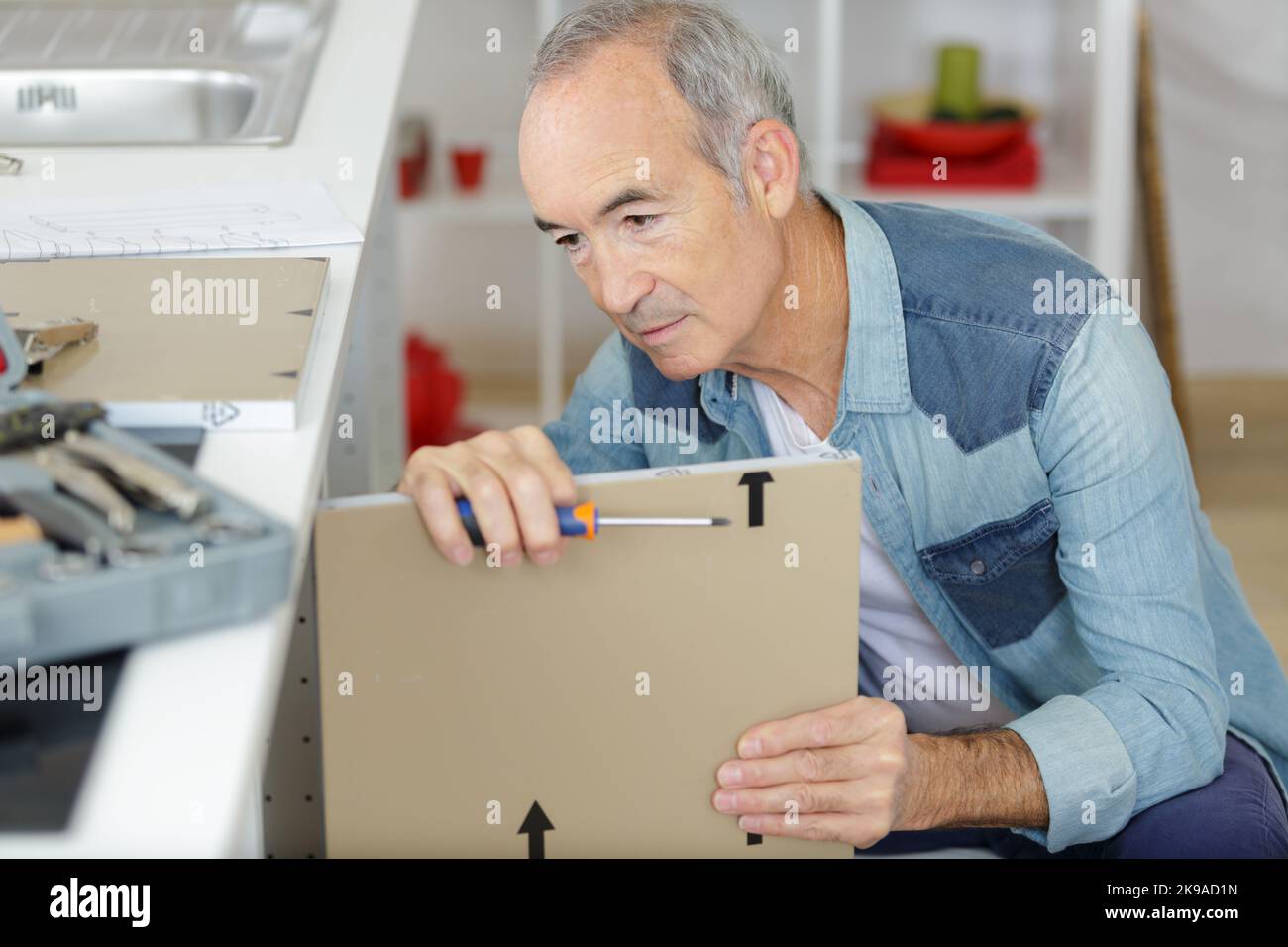 senior man fixing the cupboard door Stock Photo - Alamy