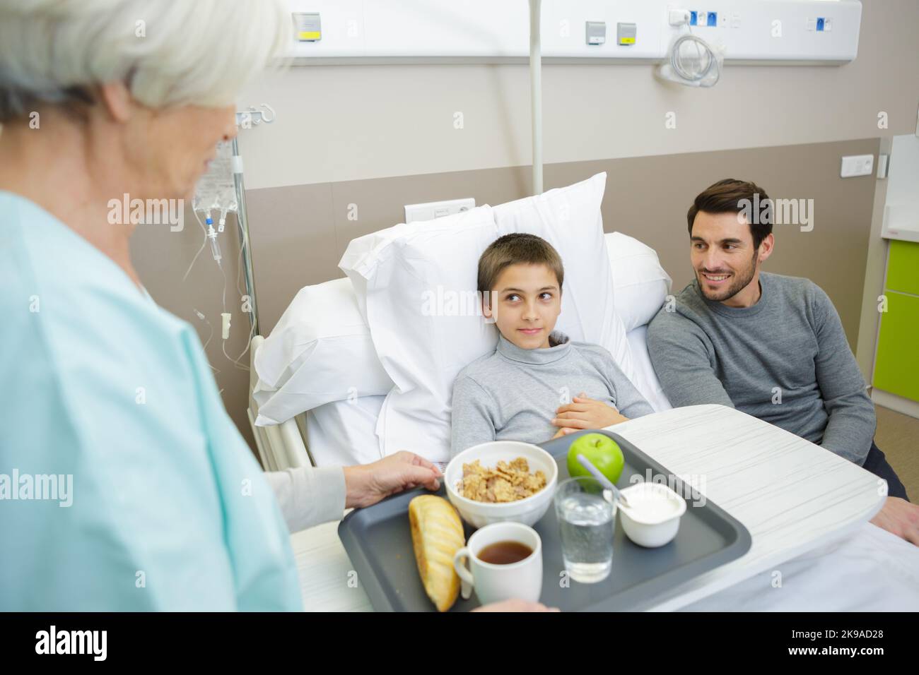 little child with intravenous drip eating soup in hospital bed Stock ...