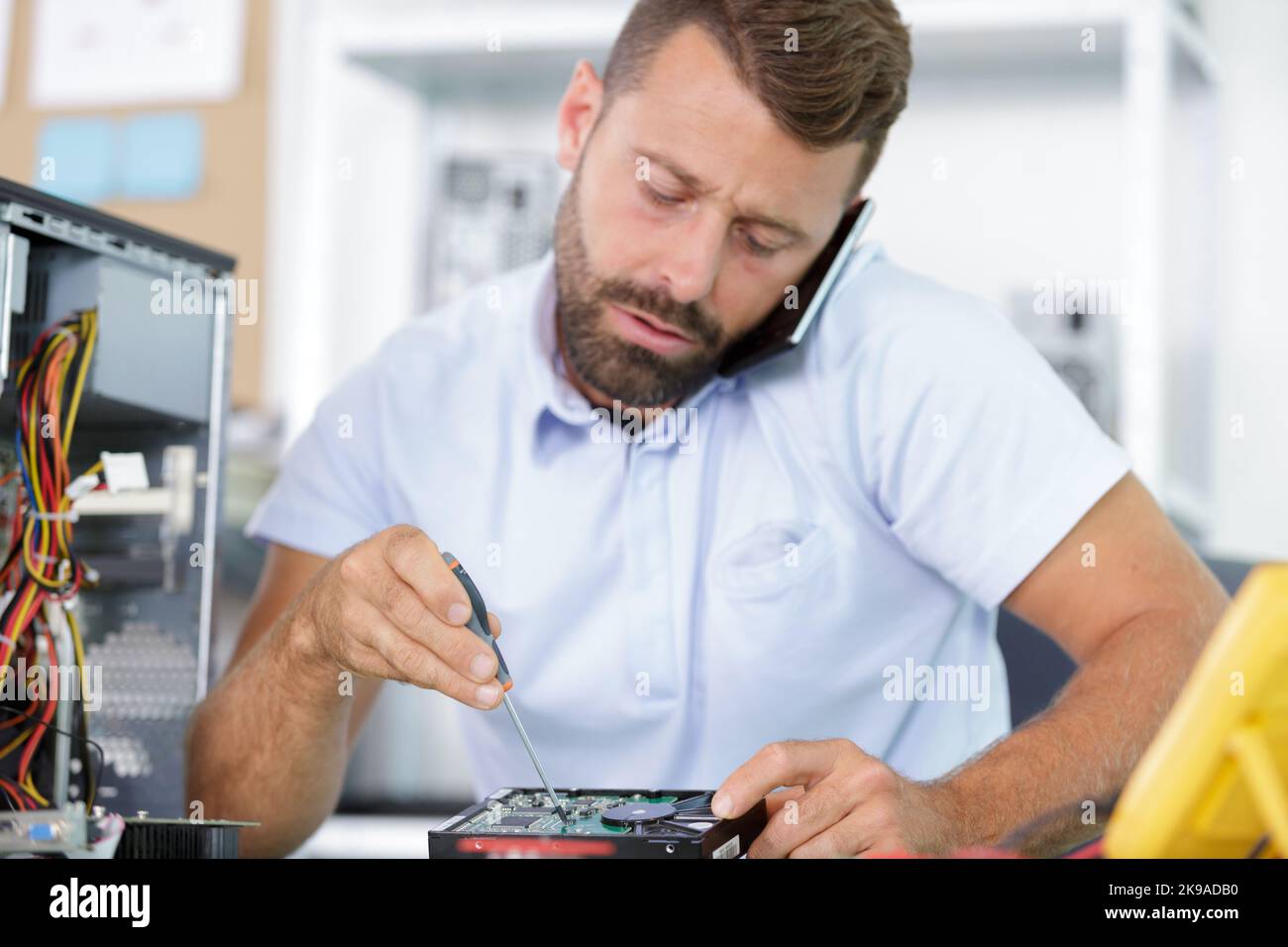 man fixing a pc while talking to customer Stock Photo - Alamy