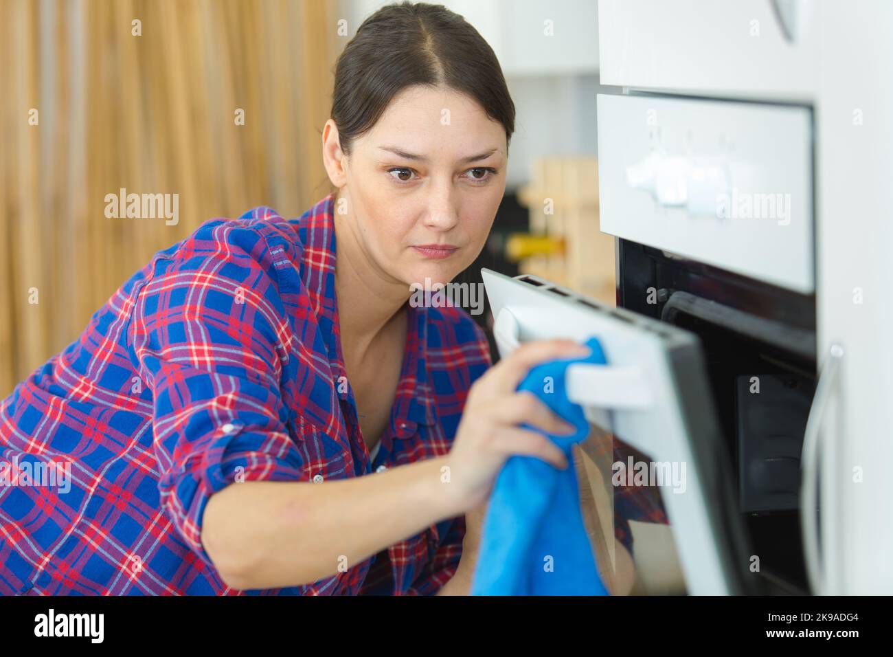 woman cleaning oven with rag Stock Photo - Alamy