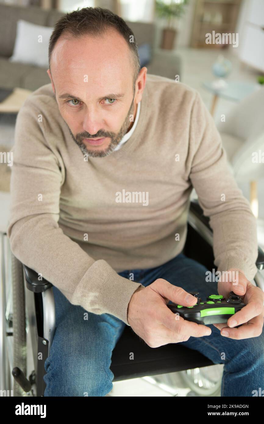 mature man in wheelchair playing computer game Stock Photo - Alamy