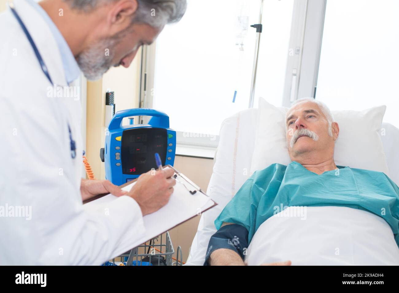 doctor writing a patients health record Stock Photo - Alamy