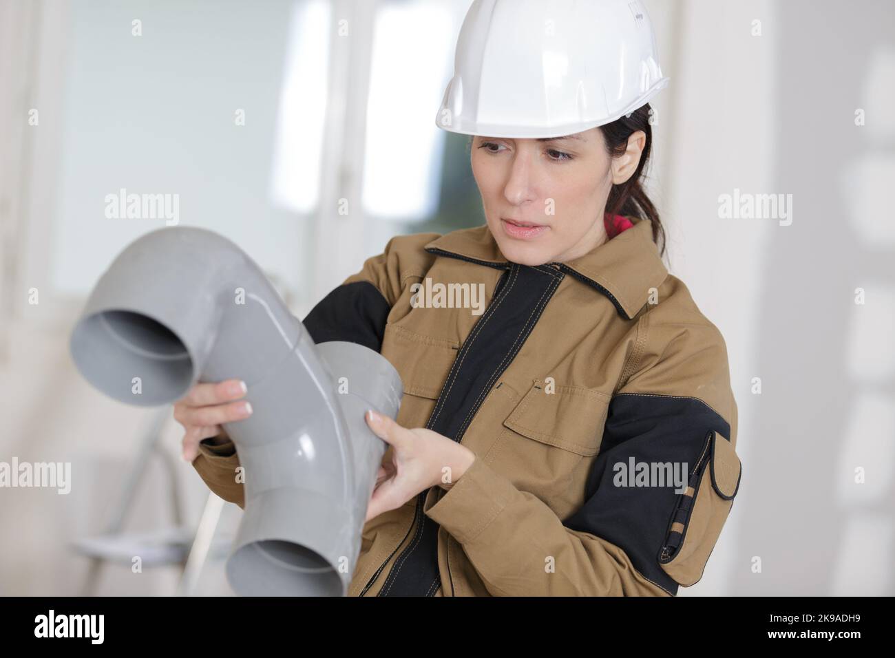 female worker holding a pvc pipe Stock Photo - Alamy