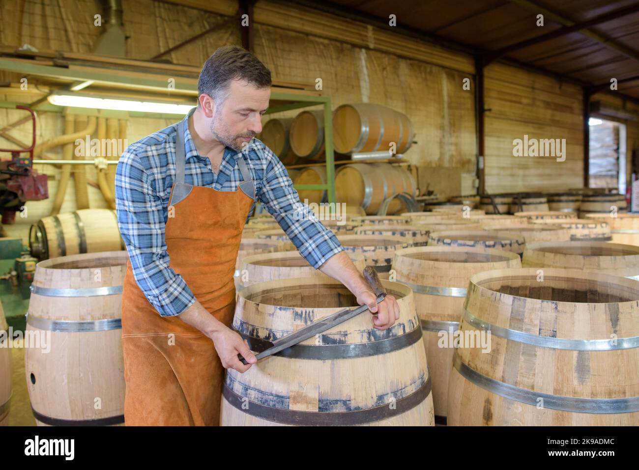Cooper putting metal hoop on barrel Stock Photo - Alamy