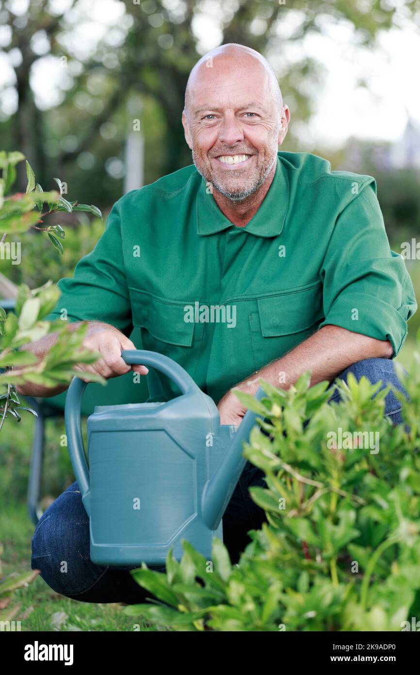 happy gardener is watering plants outdoors Stock Photo - Alamy
