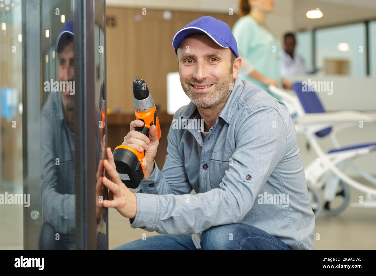 workman doing maintenance in a hospital using a cordless drill Stock ...