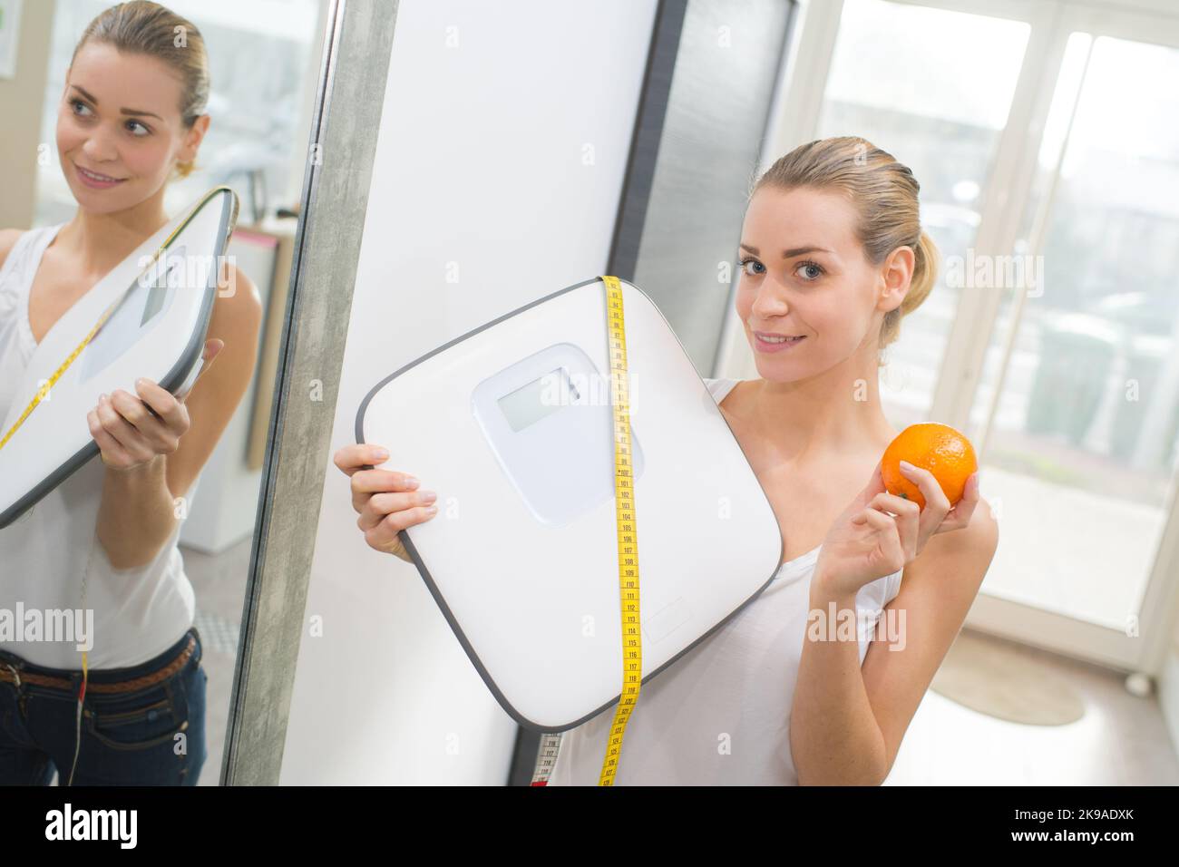 Woman holding weighing scale hi-res stock photography and images - Alamy