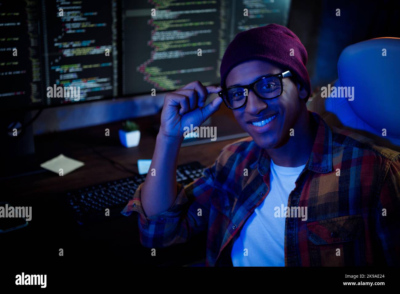 Portrait of positive handsome guy sit chair hand touch eyeglasses ...