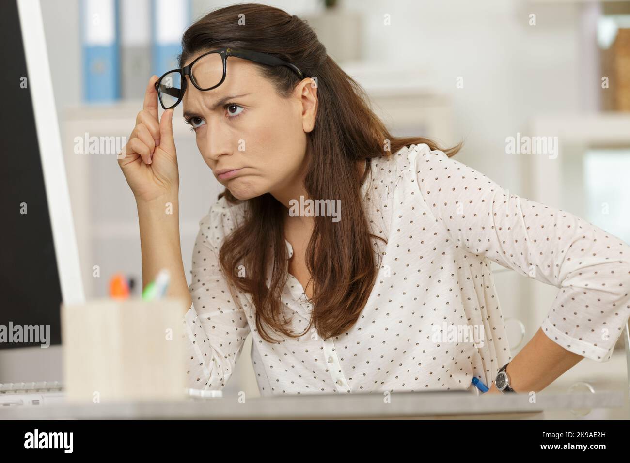lady using computer lifting her eyeglasses to see the screen Stock ...