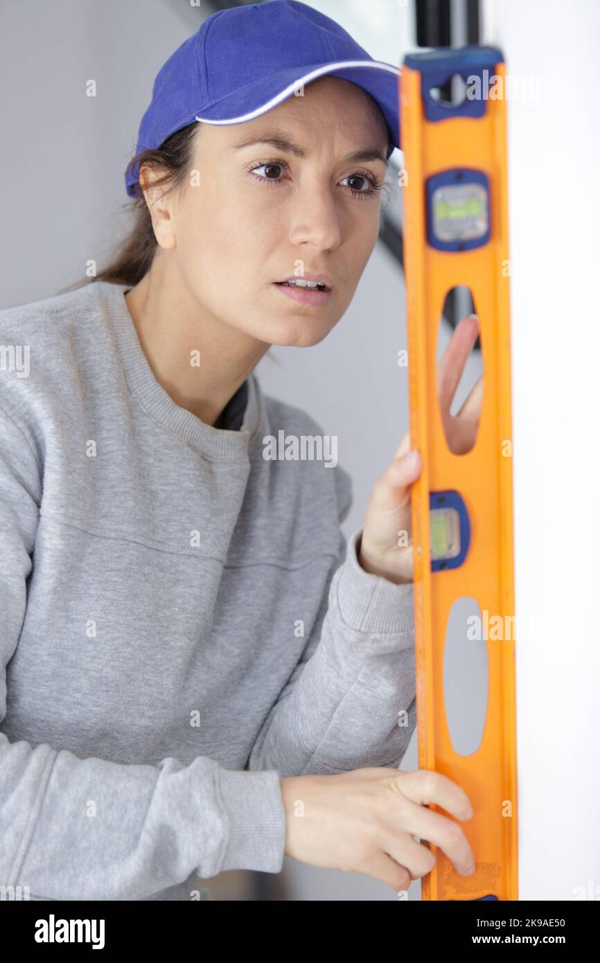 female builder using a spirit level Stock Photo - Alamy
