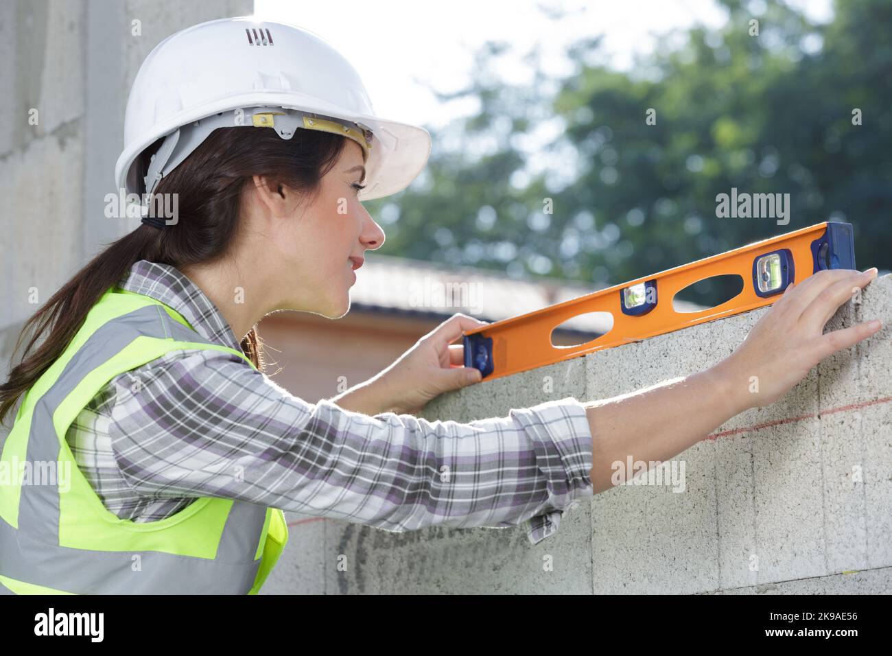 female constructor working with a level outdoors Stock Photo - Alamy