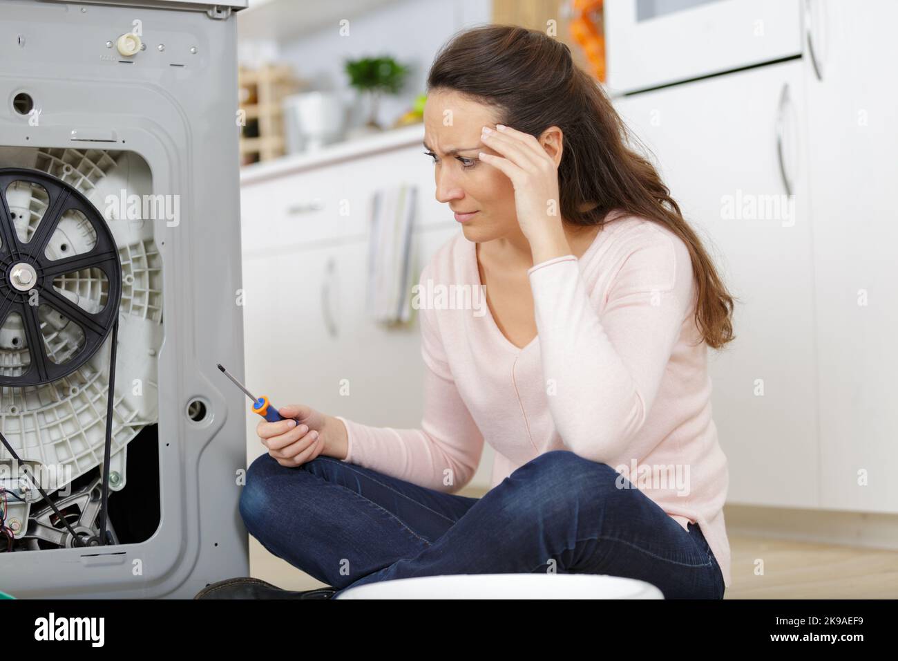 female manual looking washing machine problem Stock Photo - Alamy