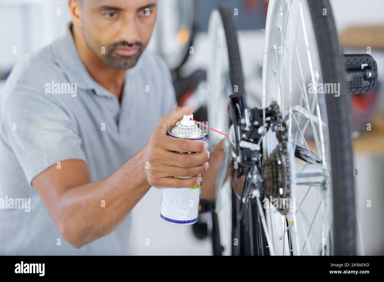 male worker oiling a bicycle chain with oil spray Stock Photo - Alamy