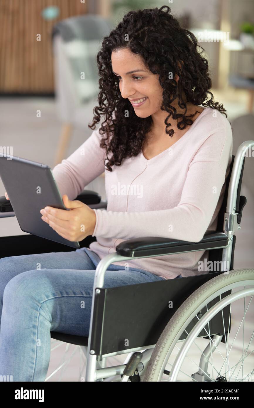 happy disable woman in wheelchair working with tablet Stock Photo - Alamy