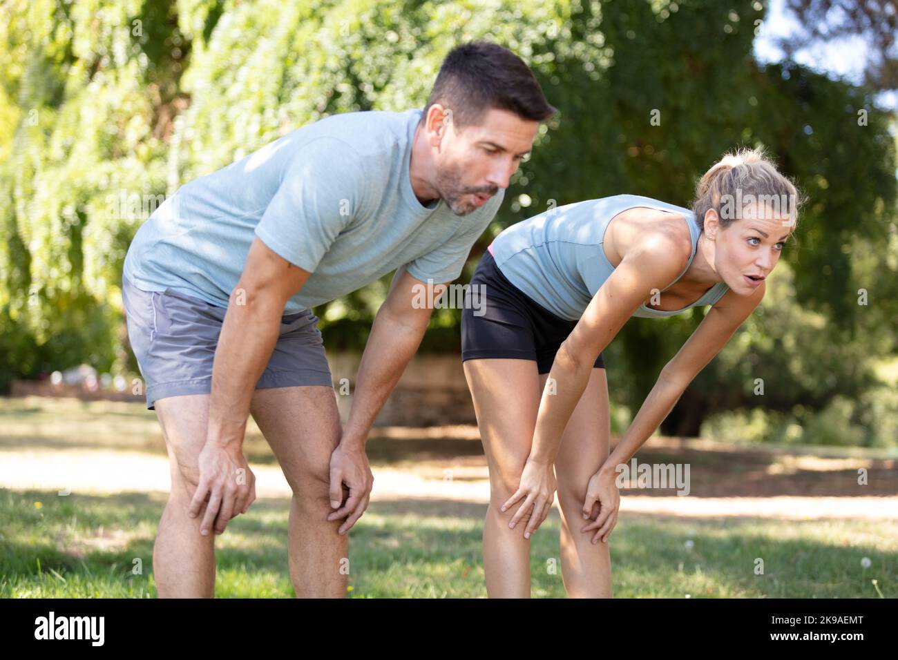 couple bending over as they recover from sport Stock Photo - Alamy
