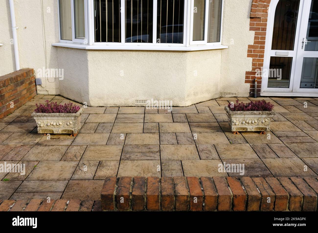 A paved over front garden with minimal flowers Stock Photo - Alamy