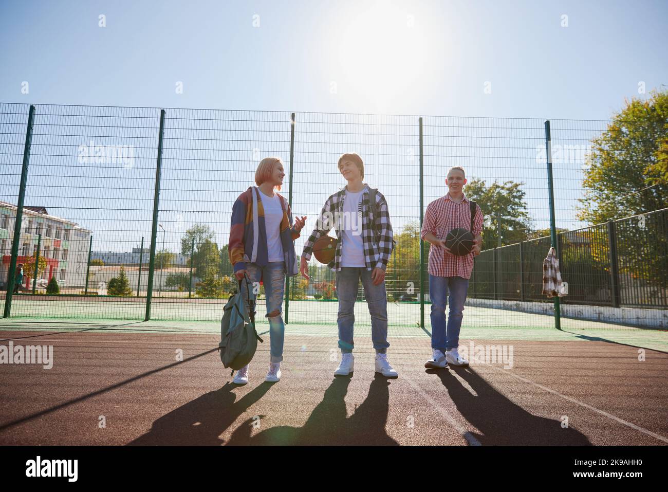 Group of friends bonding outdoors to play street basketball. Teens ...