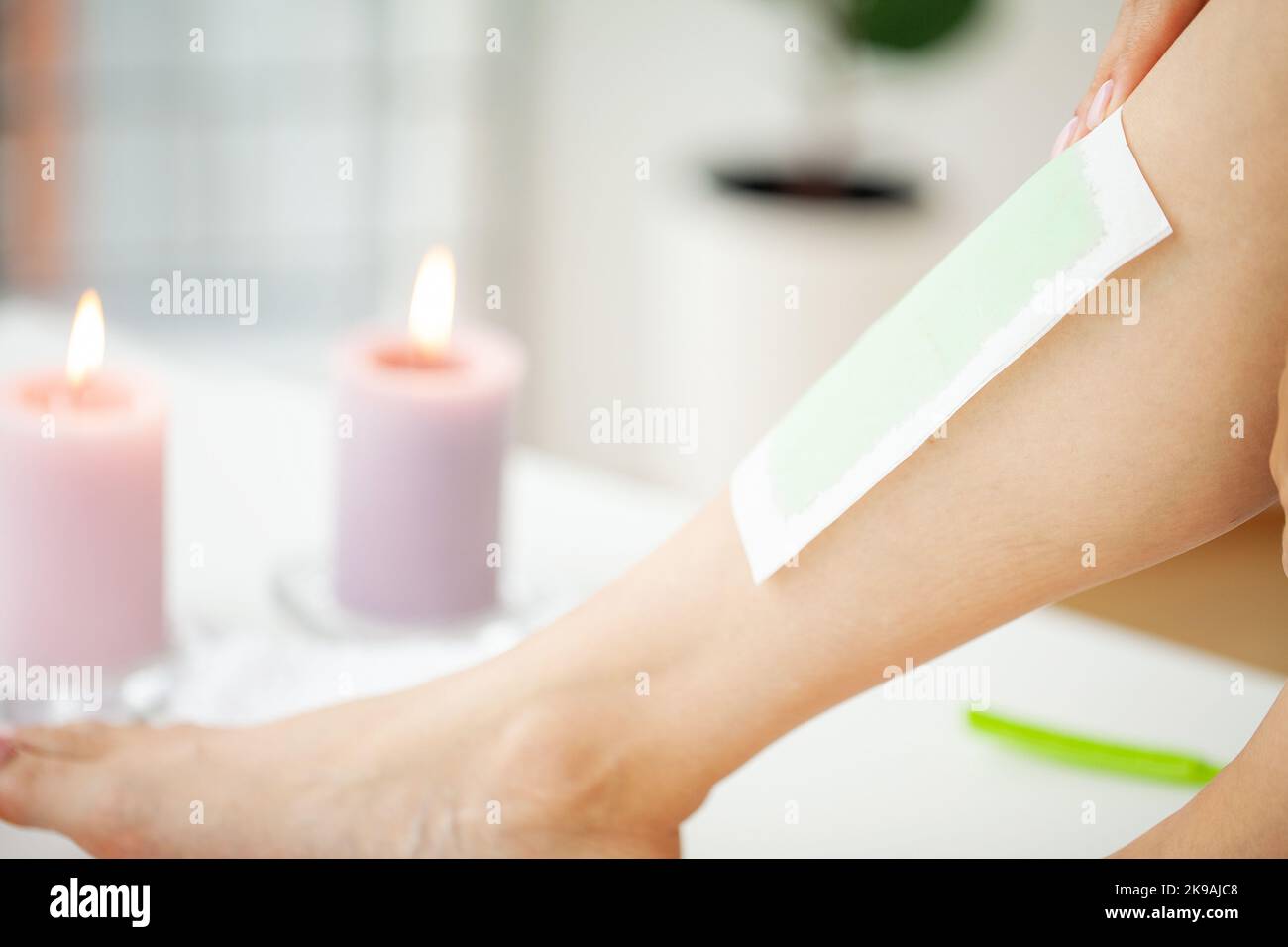 Young woman depilating her leg with wax stripe at home Stock Photo - Alamy
