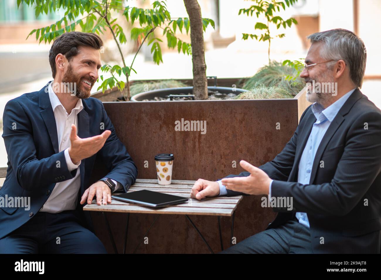 Two business partners having a conversation on an informal meeting ...