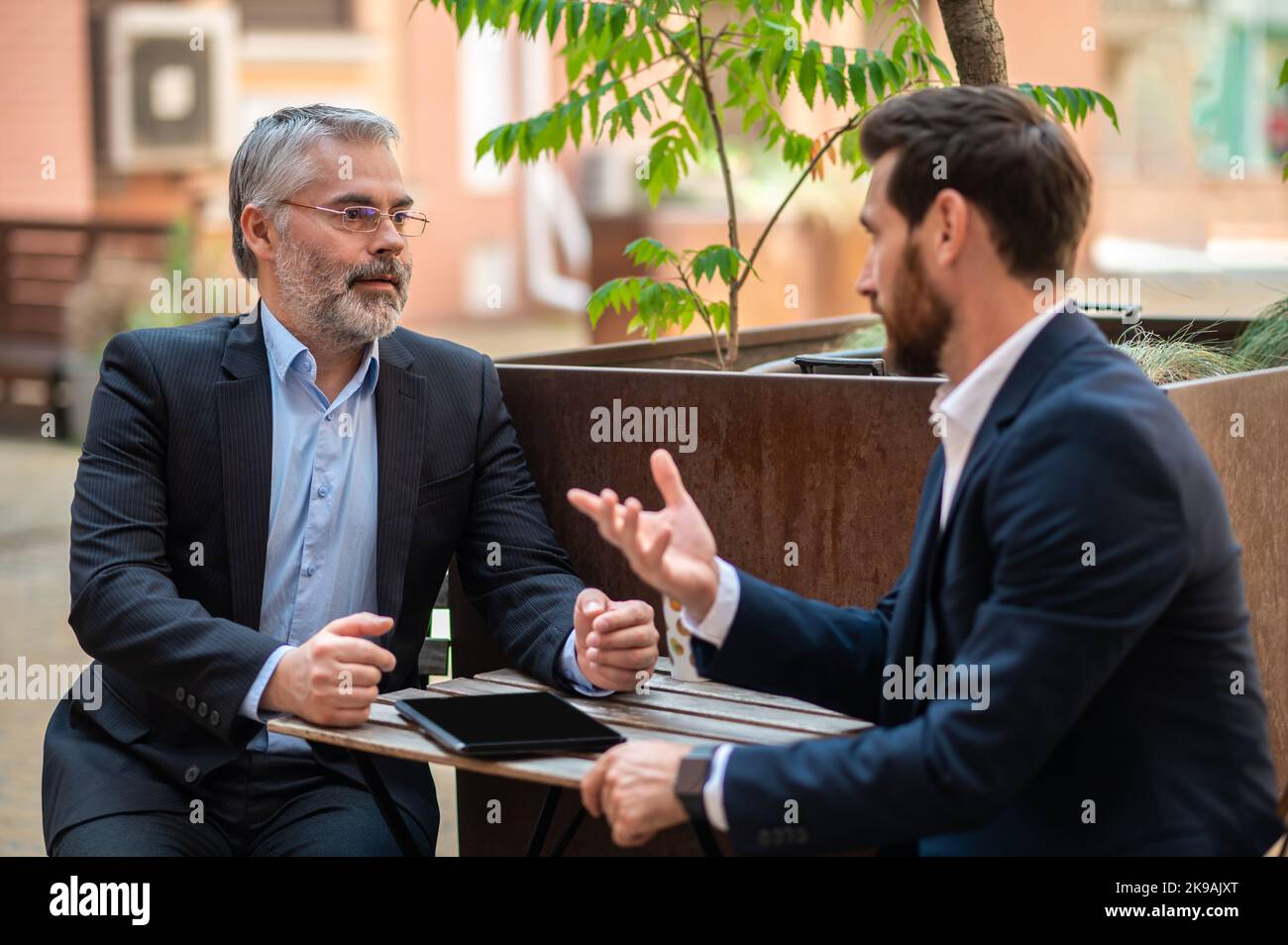 Two business partners having a conversation on an informal meeting ...