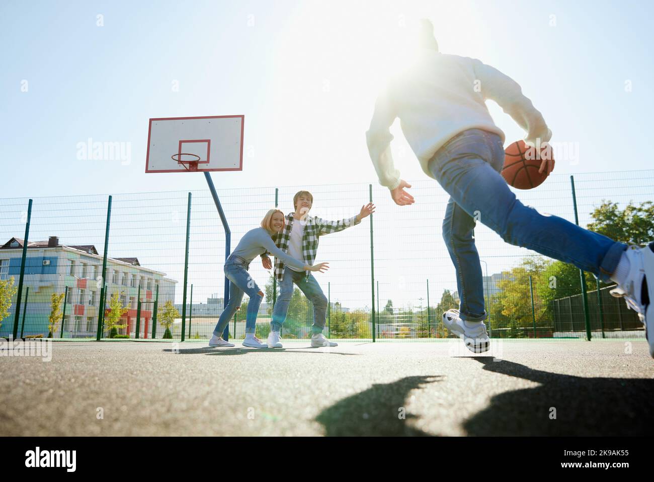 Group of teens, students playing street basketball at basketball court ...