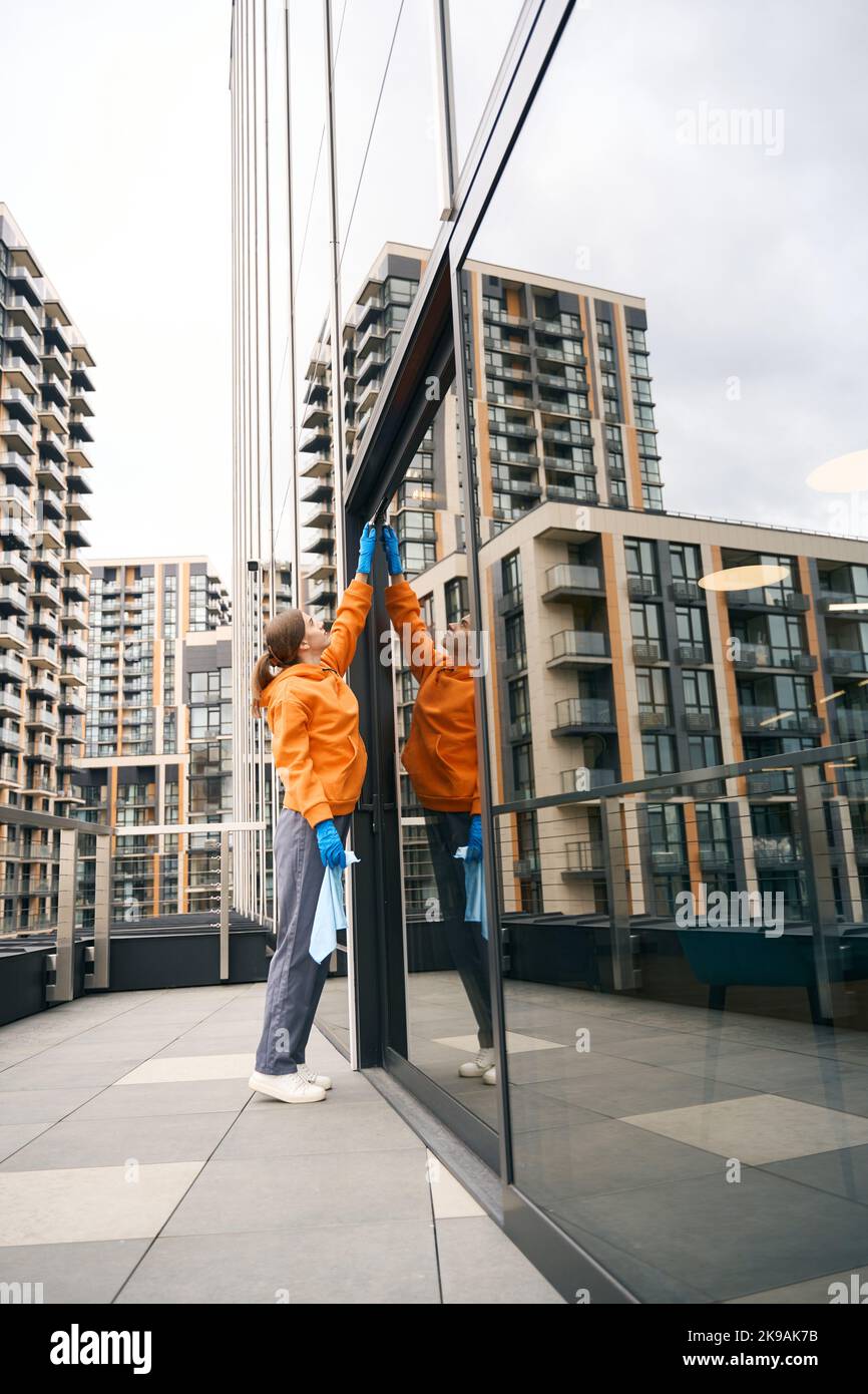 Cleaning lady cleans the mirrored windows of an office center Stock Photo - Alamy