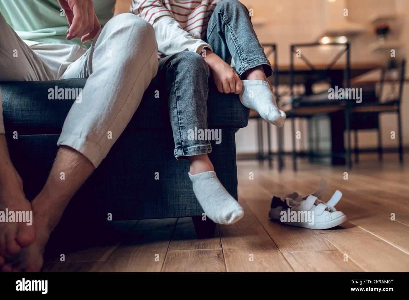 Little boy looking busy while getting on his shoes Stock Photo - Alamy