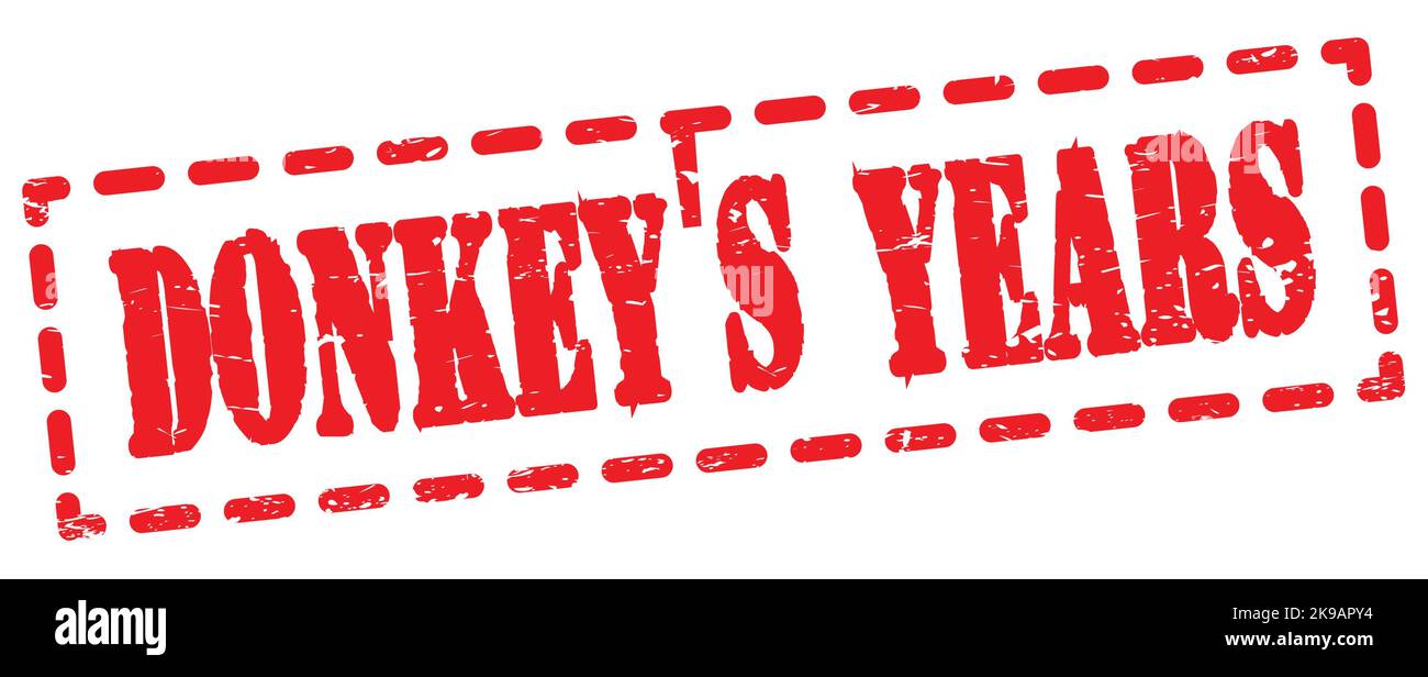 DONKEY'S YEARS text written on red dash stamp sign Stock Photo - Alamy